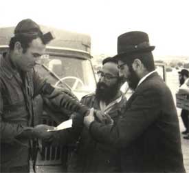 Laying tefillin on head and arm . [20]